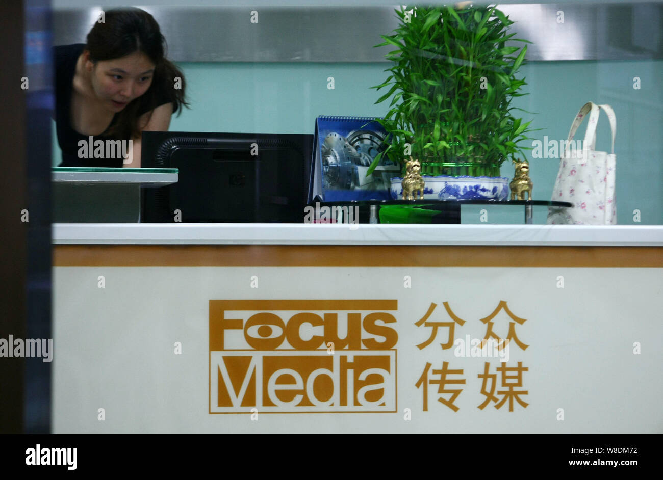--FILE--A Chinese employee is seen at the reception desk at the ...