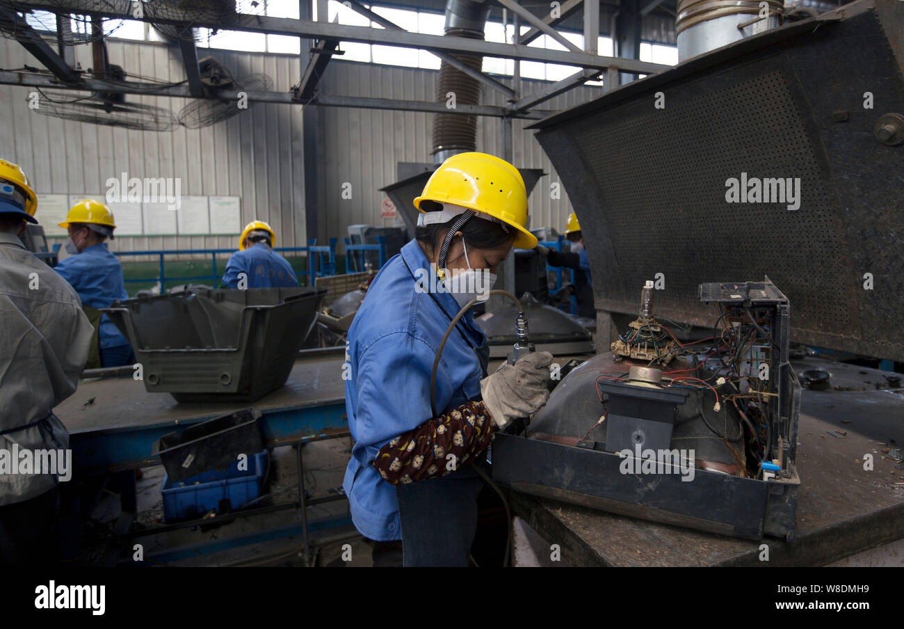 Chinese workers disassemble tube television sets in a plant at the ...