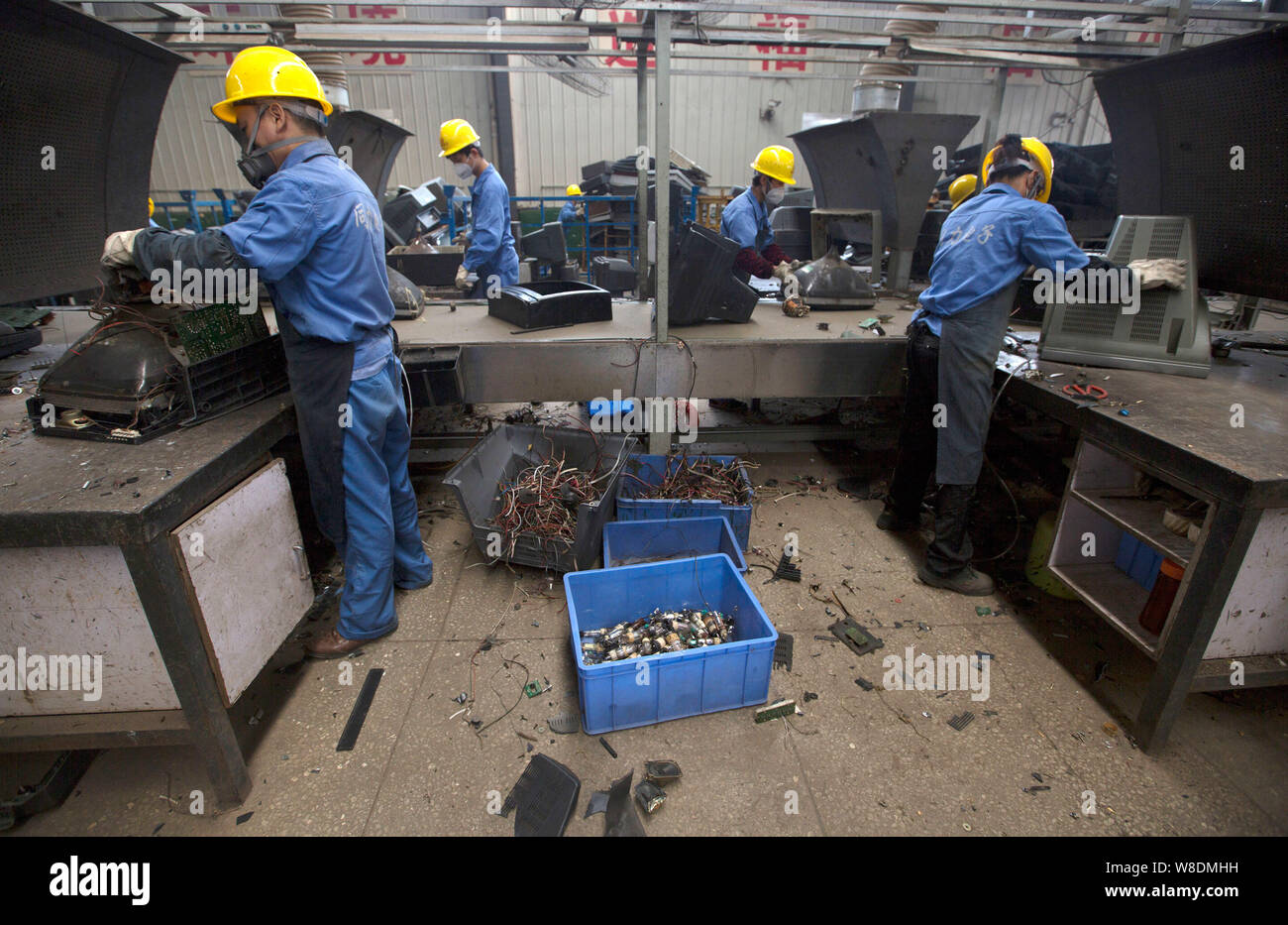 Chinese workers disassemble tube television sets in a plant at the ...