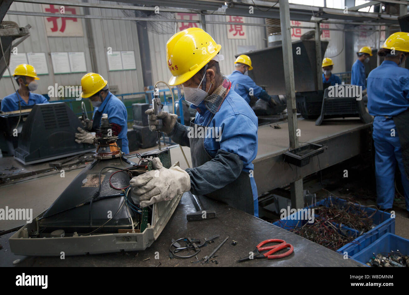 Chinese workers disassemble tube television sets in a plant at the ...