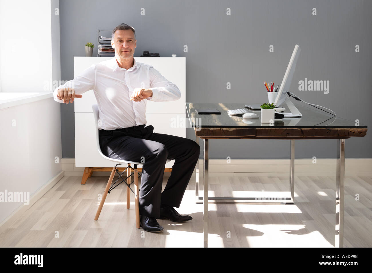 Mature businessman stretching desk hi-res stock photography and images ...