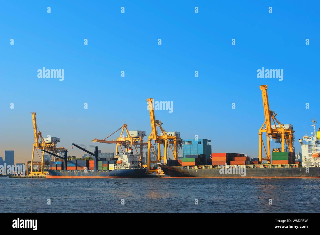 Container Cargo freight ship with working crane bridge in shipyard ...