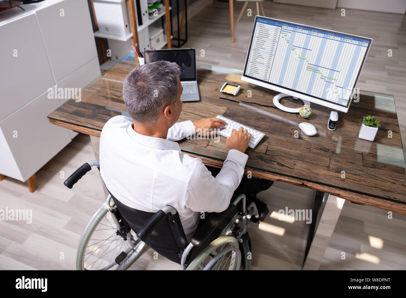 Handicapped Businessman Sitting On Wheelchair And Using Computer In ...