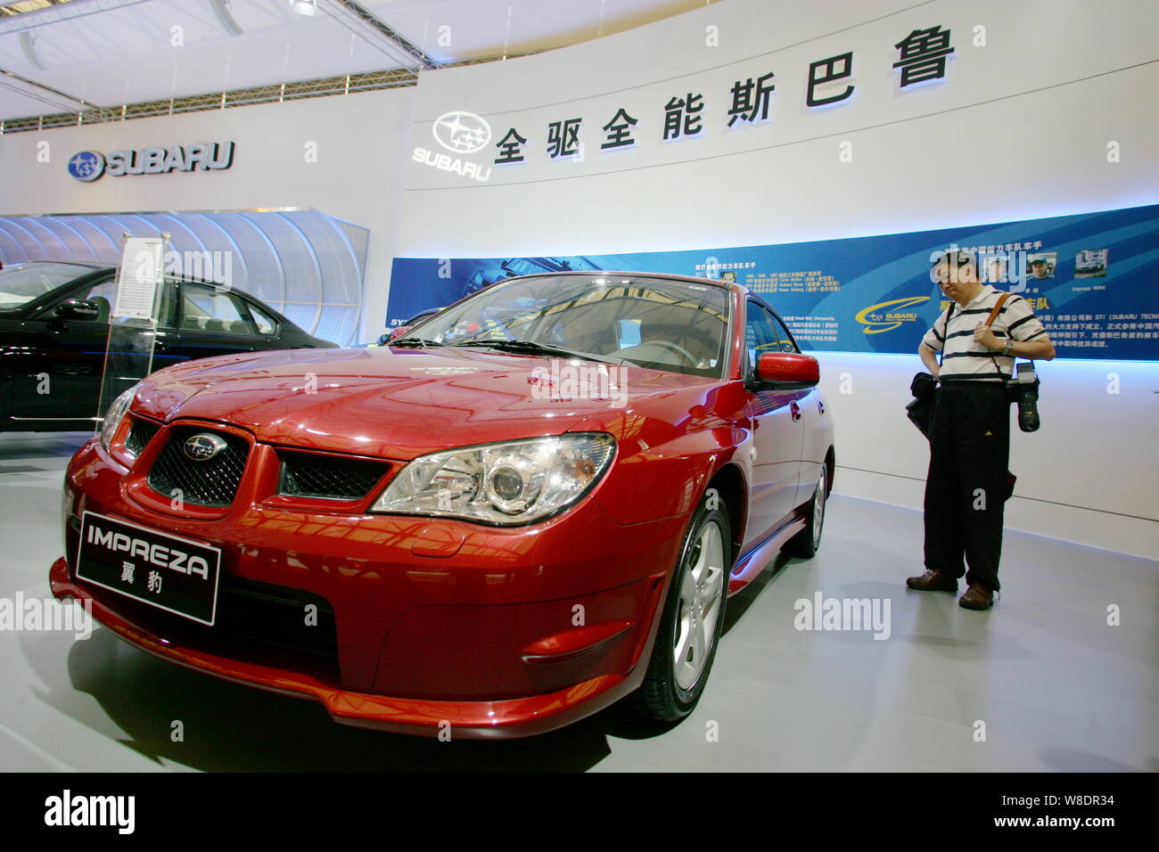 --FILE--Visitors try out or look at a Subaru Impreza on display during ...