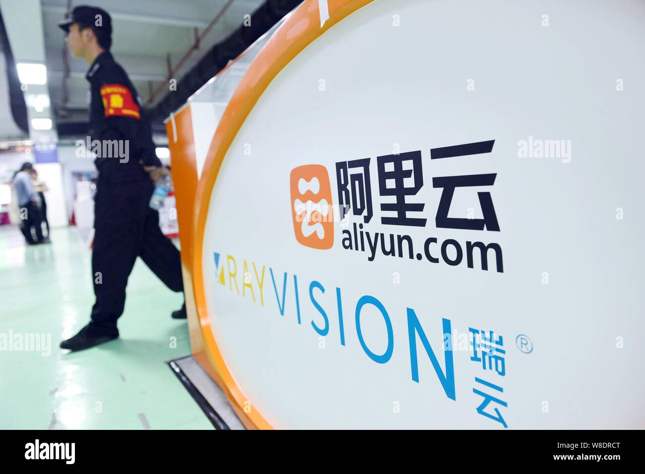 --FILE--A security guard walks past the logo of Alibaba's cloud ...