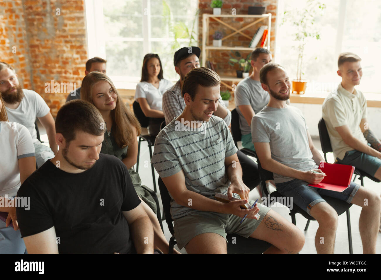 Group of students listen to presentation at university workshop ...