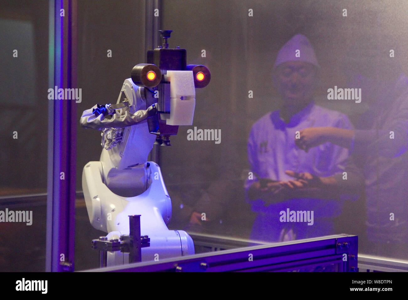 A robot cooks noodles at a new ramen restaurant in Shanghai, China, 24 ...