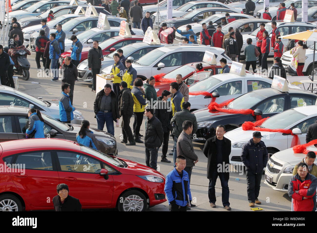 --FILE--Chinese visitors look at cars on display during an auto show in ...