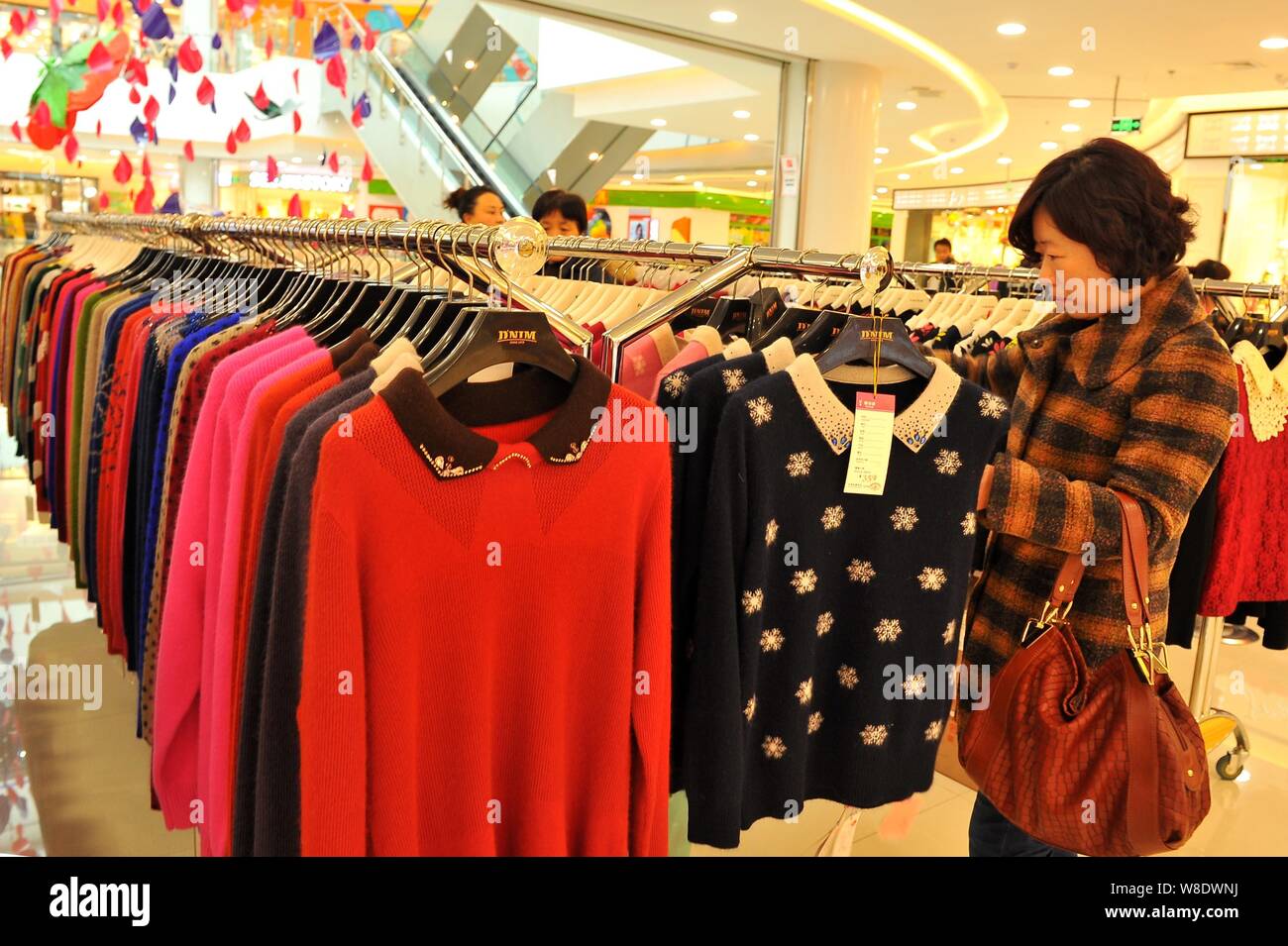 --FILE--A customer buys clothes at a shopping mall in Qingdao city ...