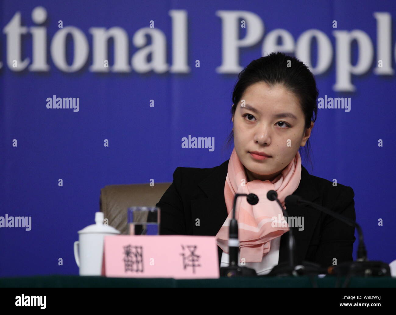 A female Chinese interpreter listens during a press conference for the ...