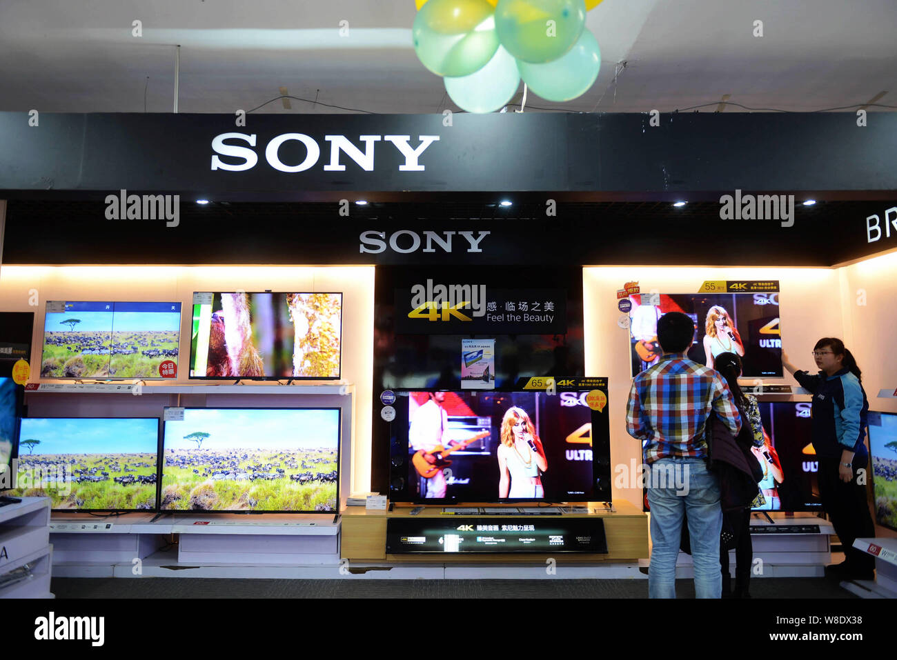 --FILE--A Chinese employee introduces Sony 4K televisions to customers ...
