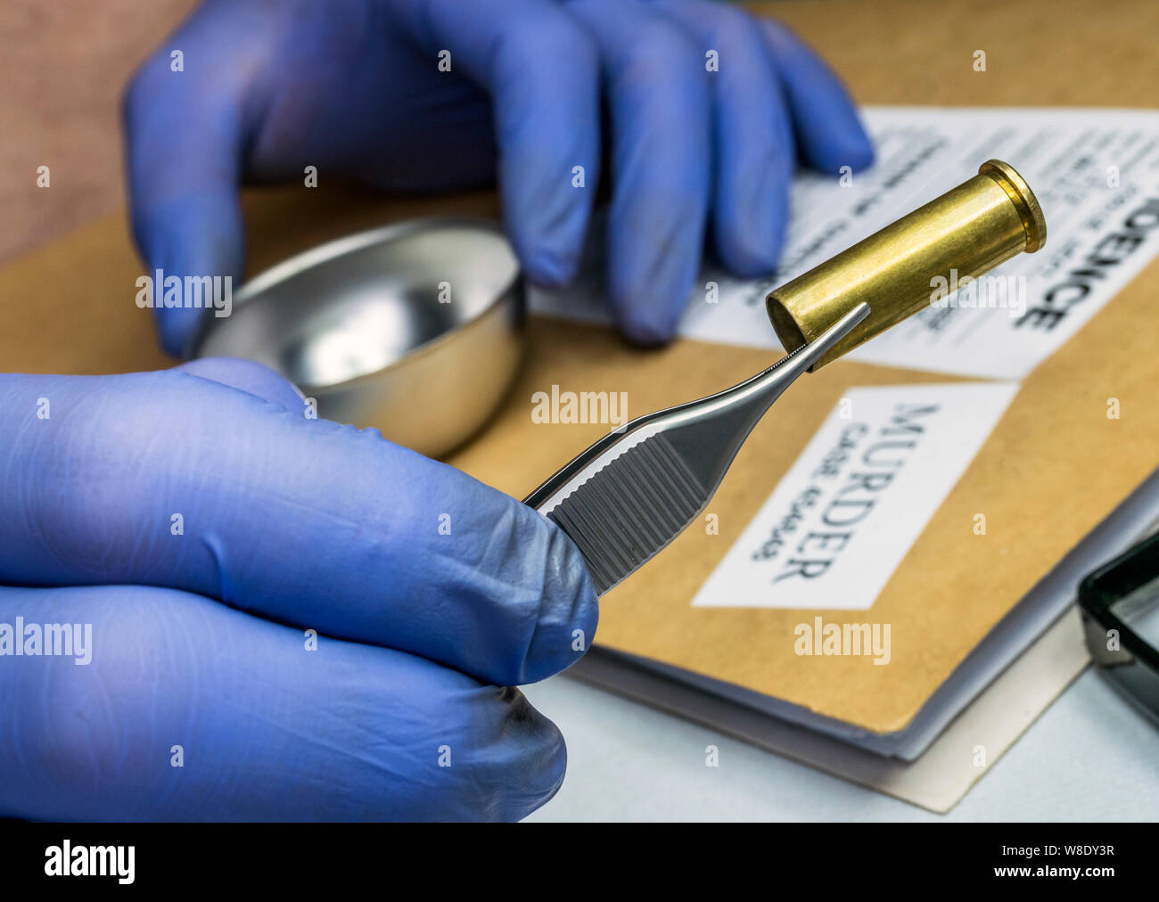 Scientific police examining a bullet cap in ballistic Laboratory ...