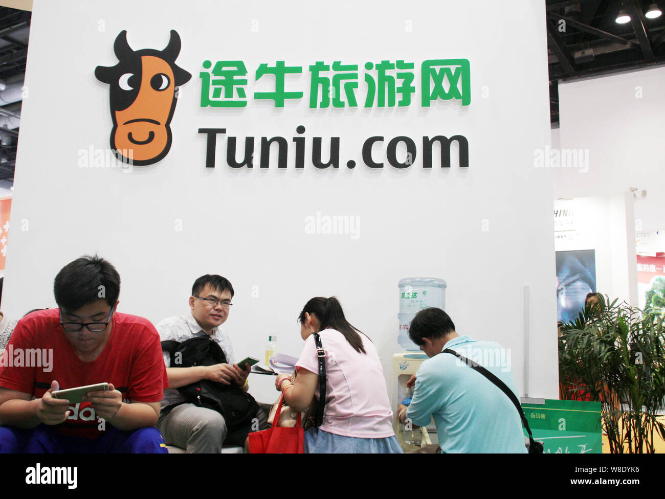 --FILE--Chinese visitors rest at the stand of online travel agency ...