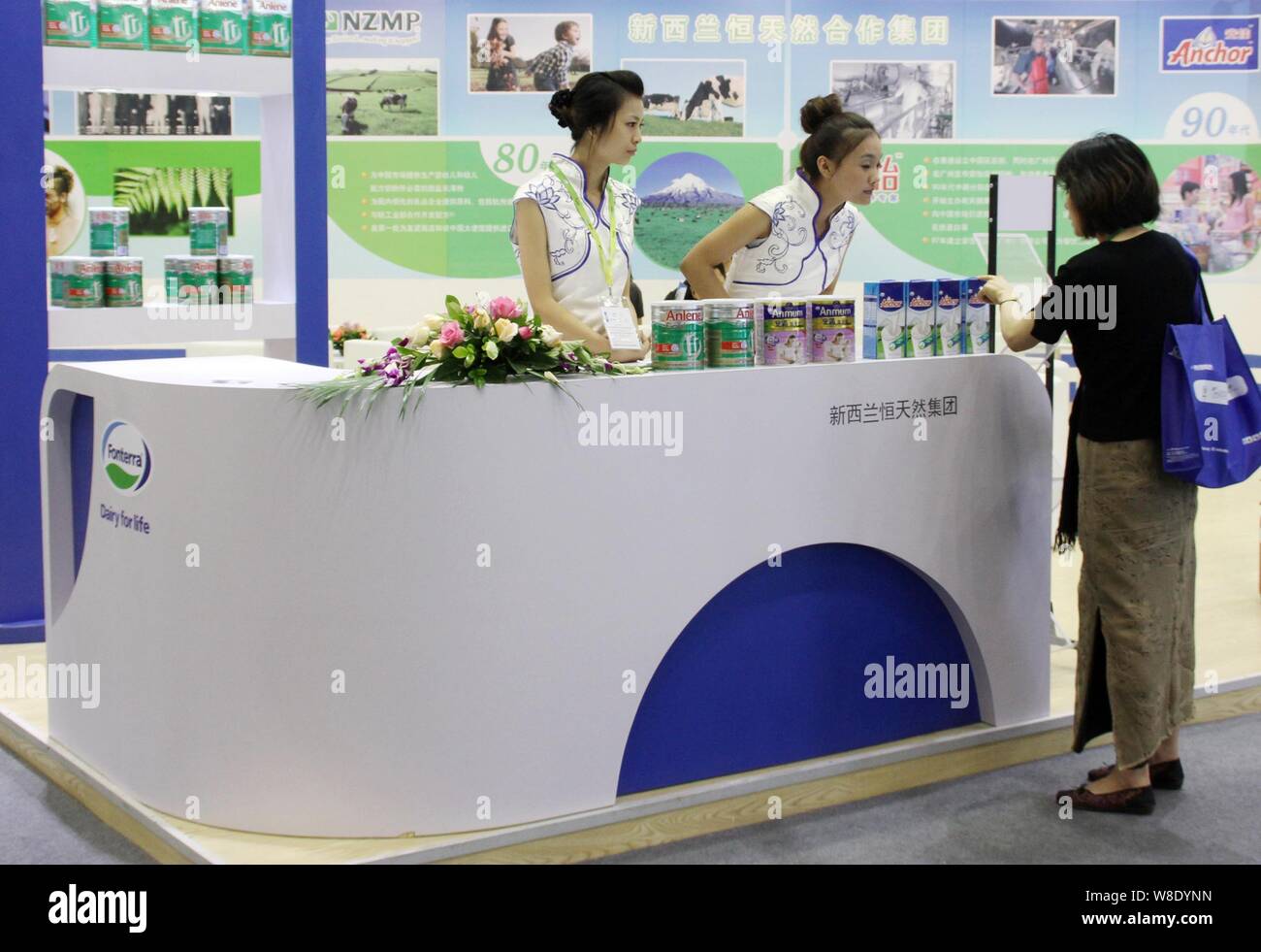--FILE--Chinese employees deal with a visitor at the stand of Fonterra ...
