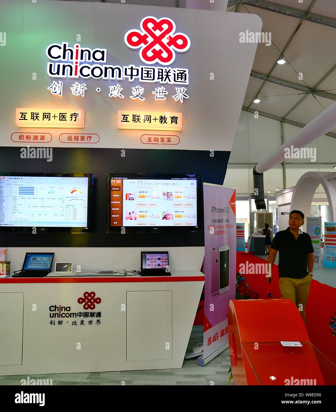 --FILE--A visitor walks past the stand of China Unicom during an ...