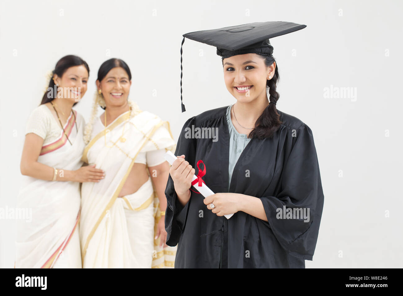 Graduate student holding graduation degree with her family in the ...