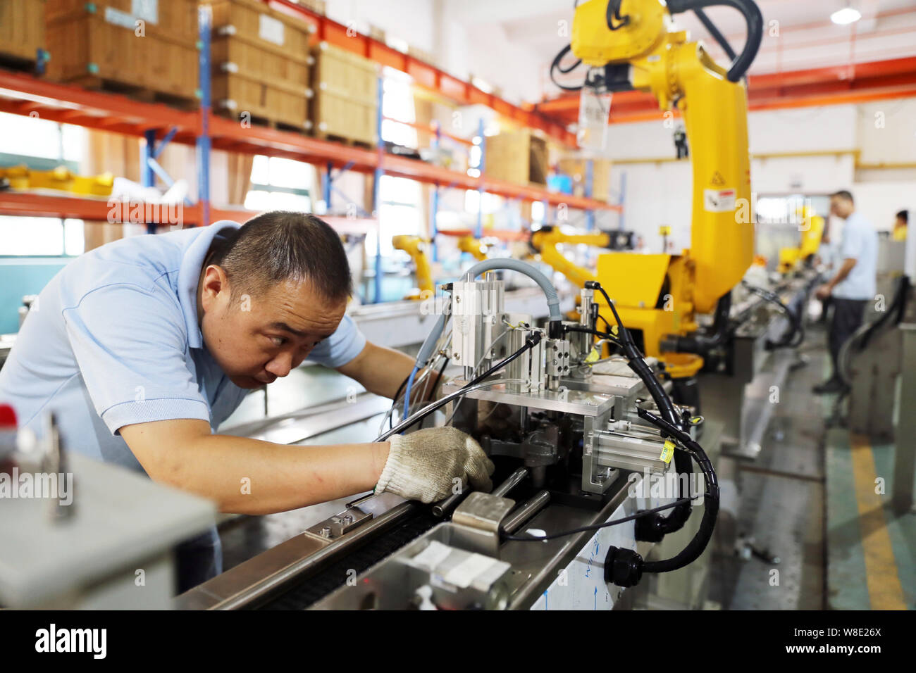 Chinese factory workers test robot arms at the plant of Zhejiang ...