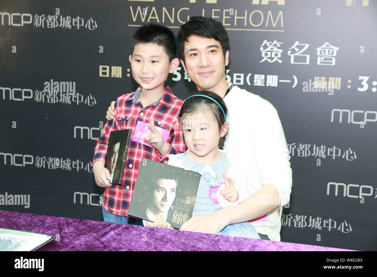 Taiwan-based American singer Leehom Wang poses with children at a ...