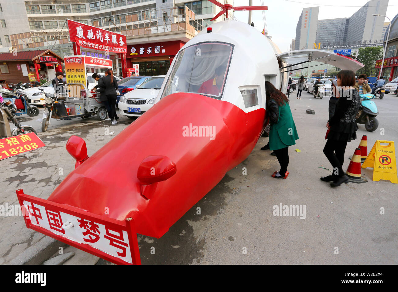 Pedestrians look at the homemade helicopter-shaped vehicle built by ...