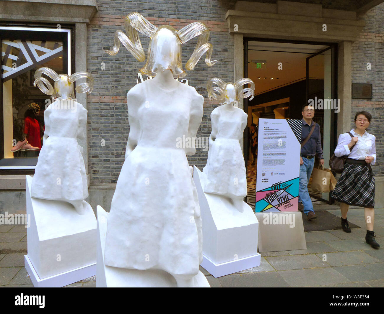 Visitors look at an art installation during a shop window design ...