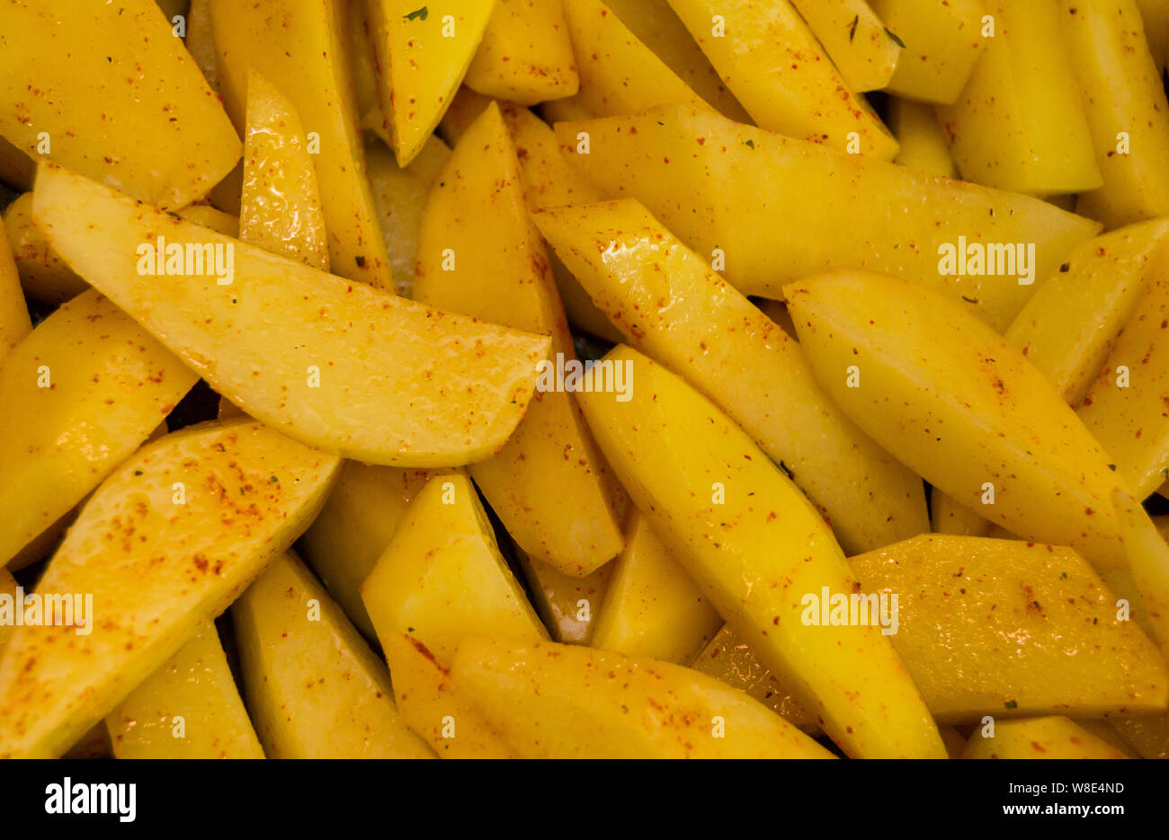 Fresh cut potatoes sliced and seasoned close-up Stock Photo - Alamy