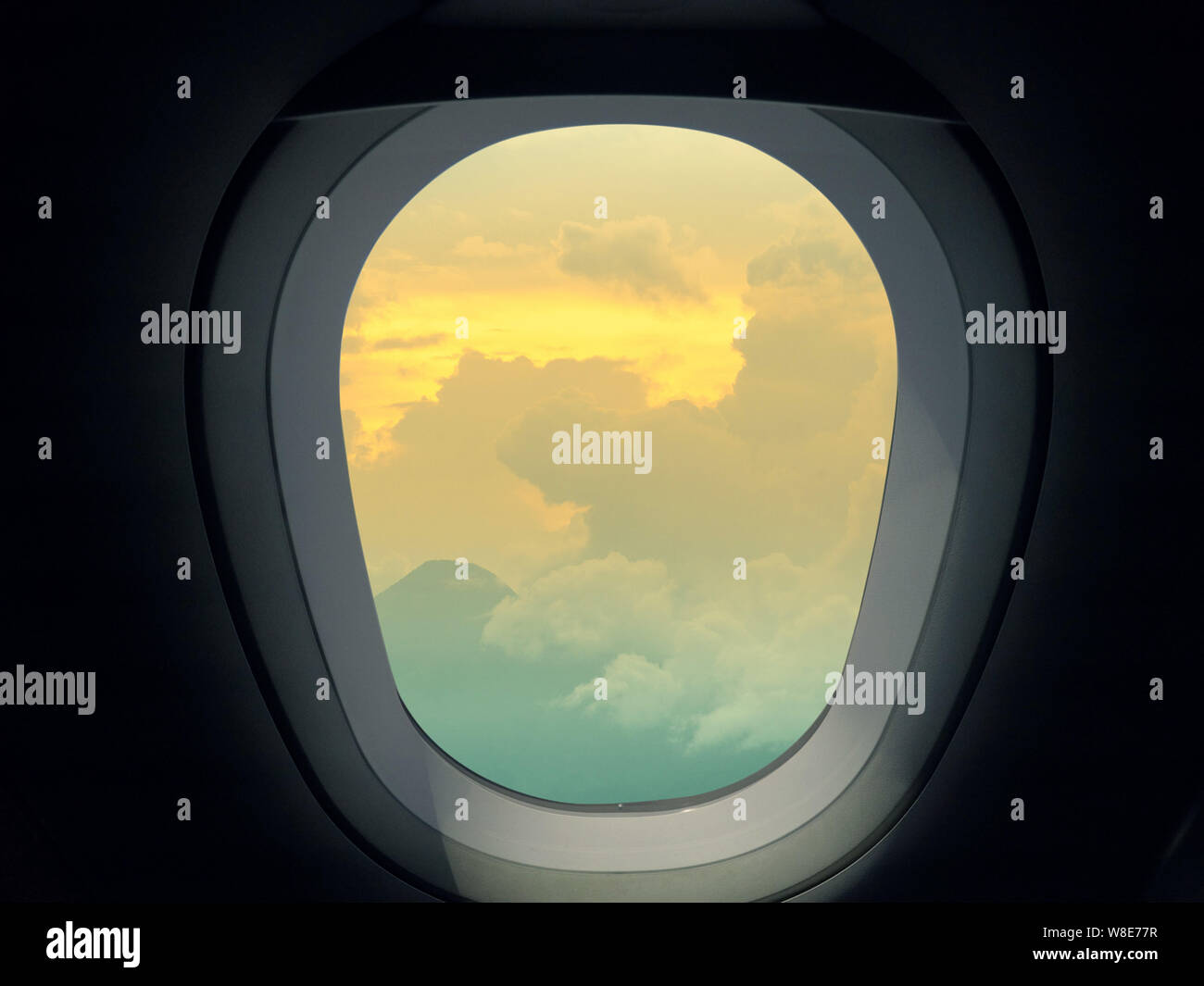 View from passenger's seat in airplane flying above clouds in dramatic ...