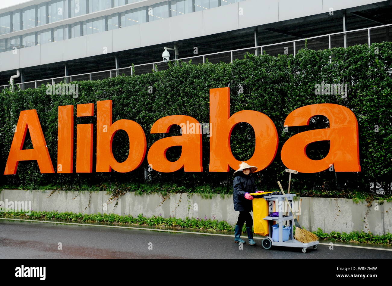 --FILE--A Chinese cleaning worker pushes a cart past the headquarters ...