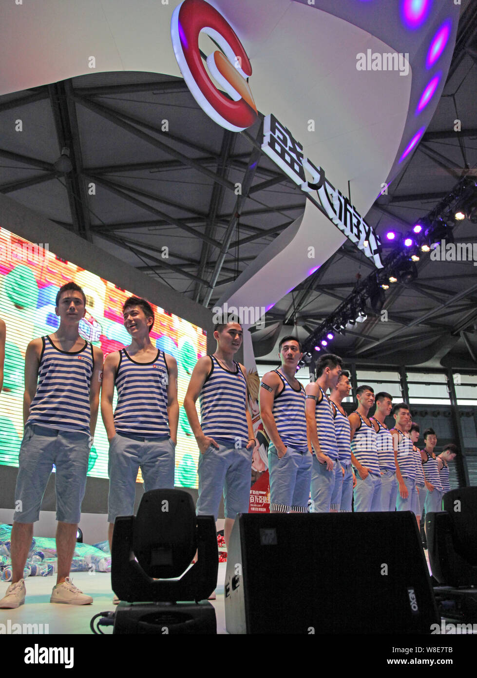 --FILE--Male models pose at the stand of Shanda Games during the 11th ...