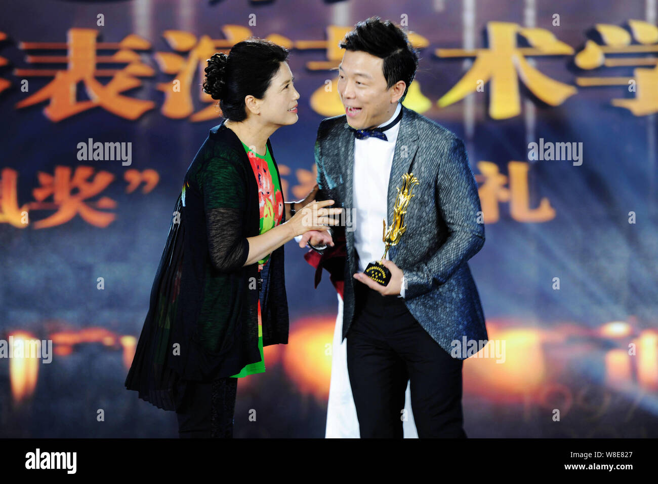 Chinese actor Huang Bo, right, receives an award at the 15th Golden ...