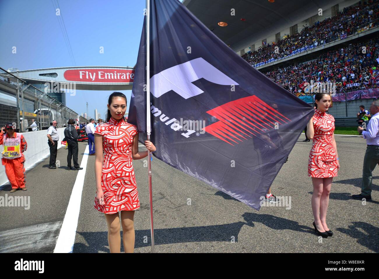 Hostesses display a flag of F1 during the 2015 Formula 1 Chinese Grand ...