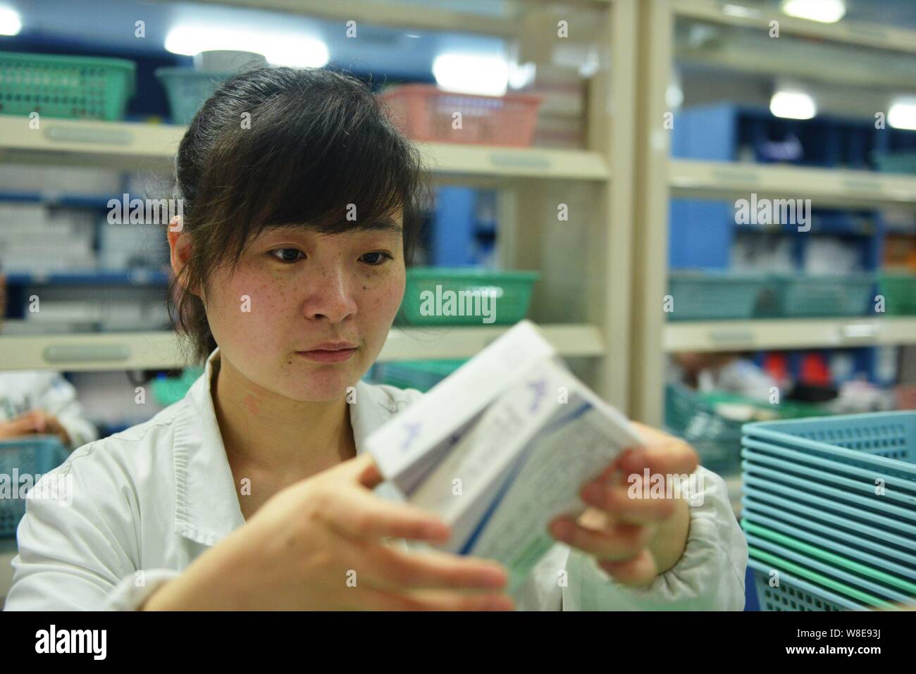 --FILE--A Chinese medical worker dispenses medicines according to a ...