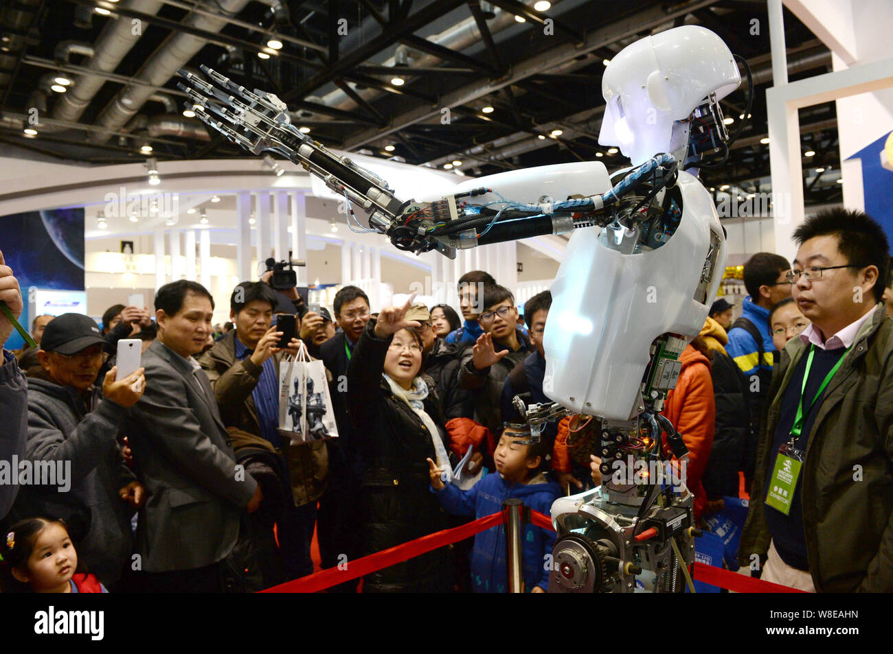 Visitors look at a robot of Tami Intelligence on display during the ...