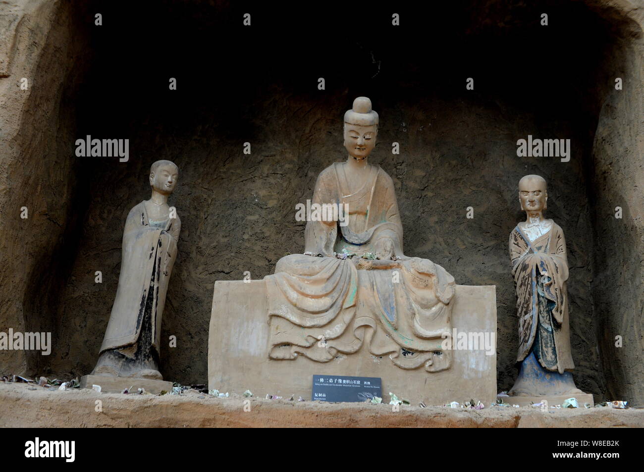 Banknotes thrown by believers are placed near Buddha statues to pray ...
