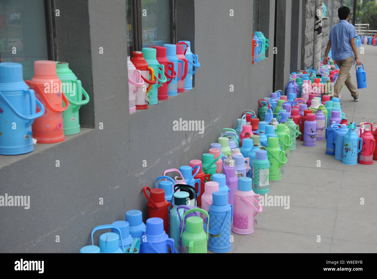 Colorful thermos flasks are placed by students in front of the public ...