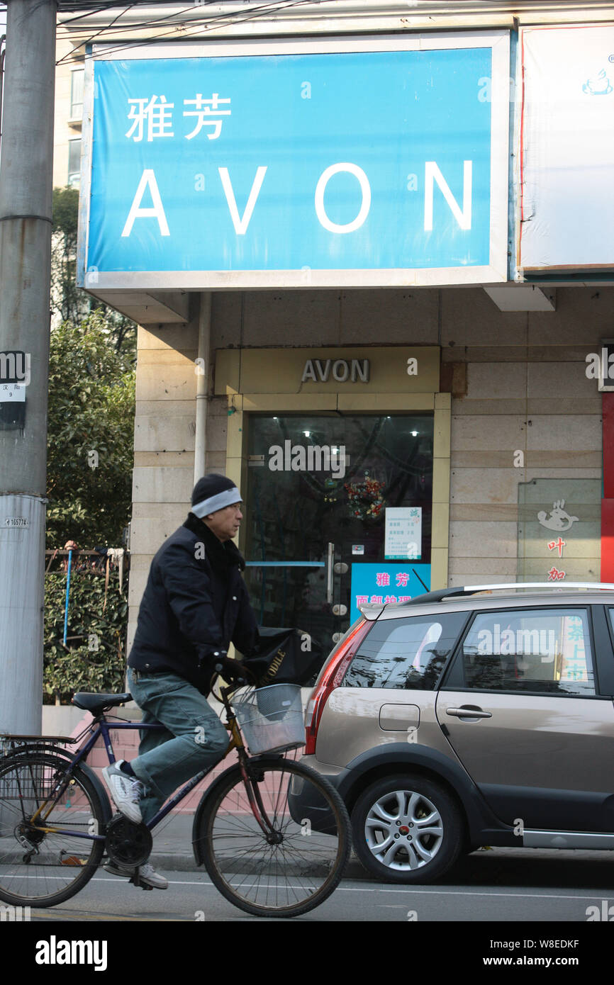 --FILE--A cyclist rides past a shop of Avon in Shanghai, China, 12 ...