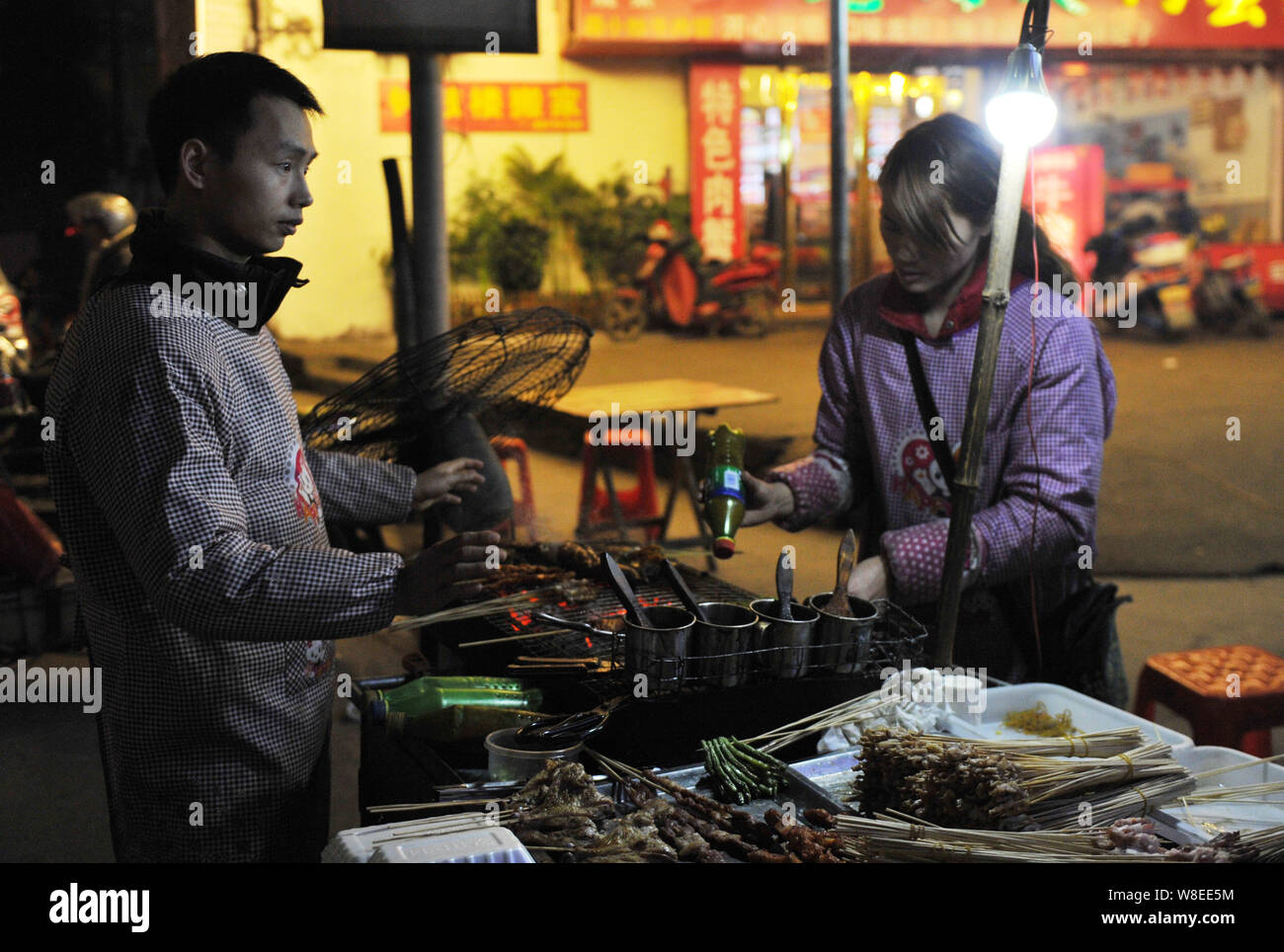 --FILE--Chinese vendors prepare food at a roadside barbecue stall in ...