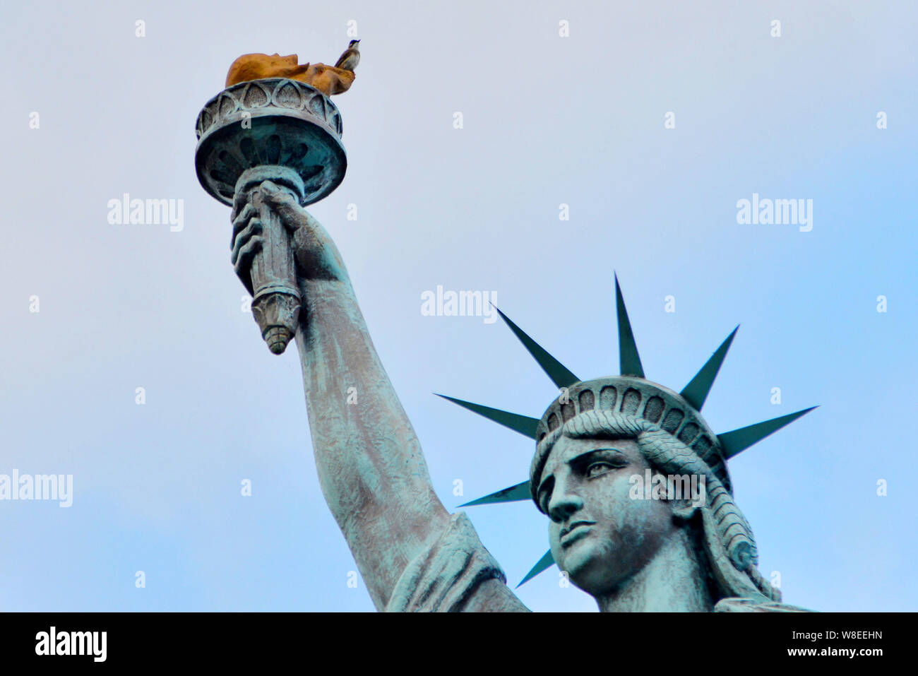 A bird stands atop a downsized replica of the Statue of Liberty in the ...