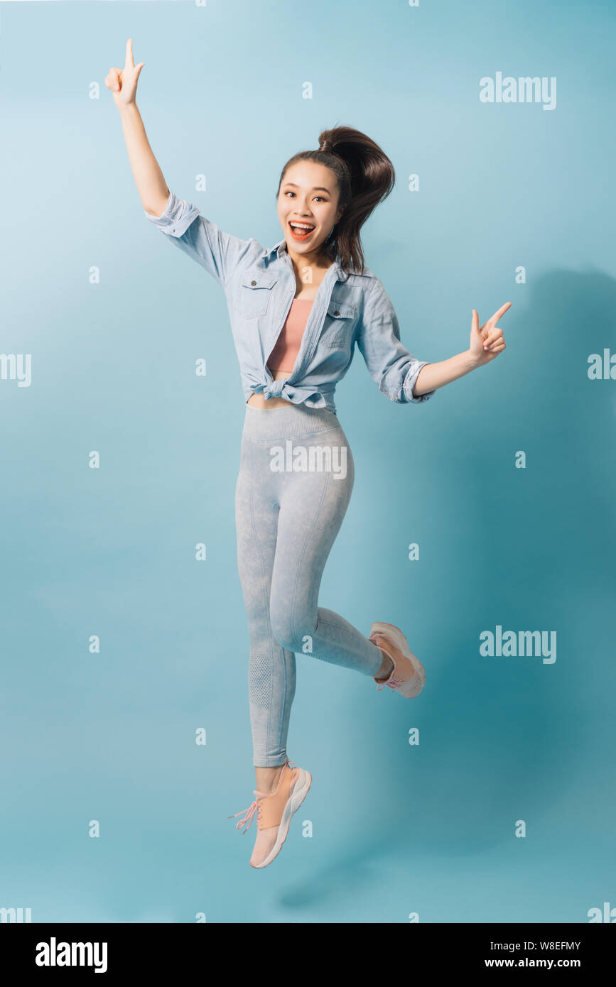 Portrait of playful crazy girl jumping in the air looking at camera ...