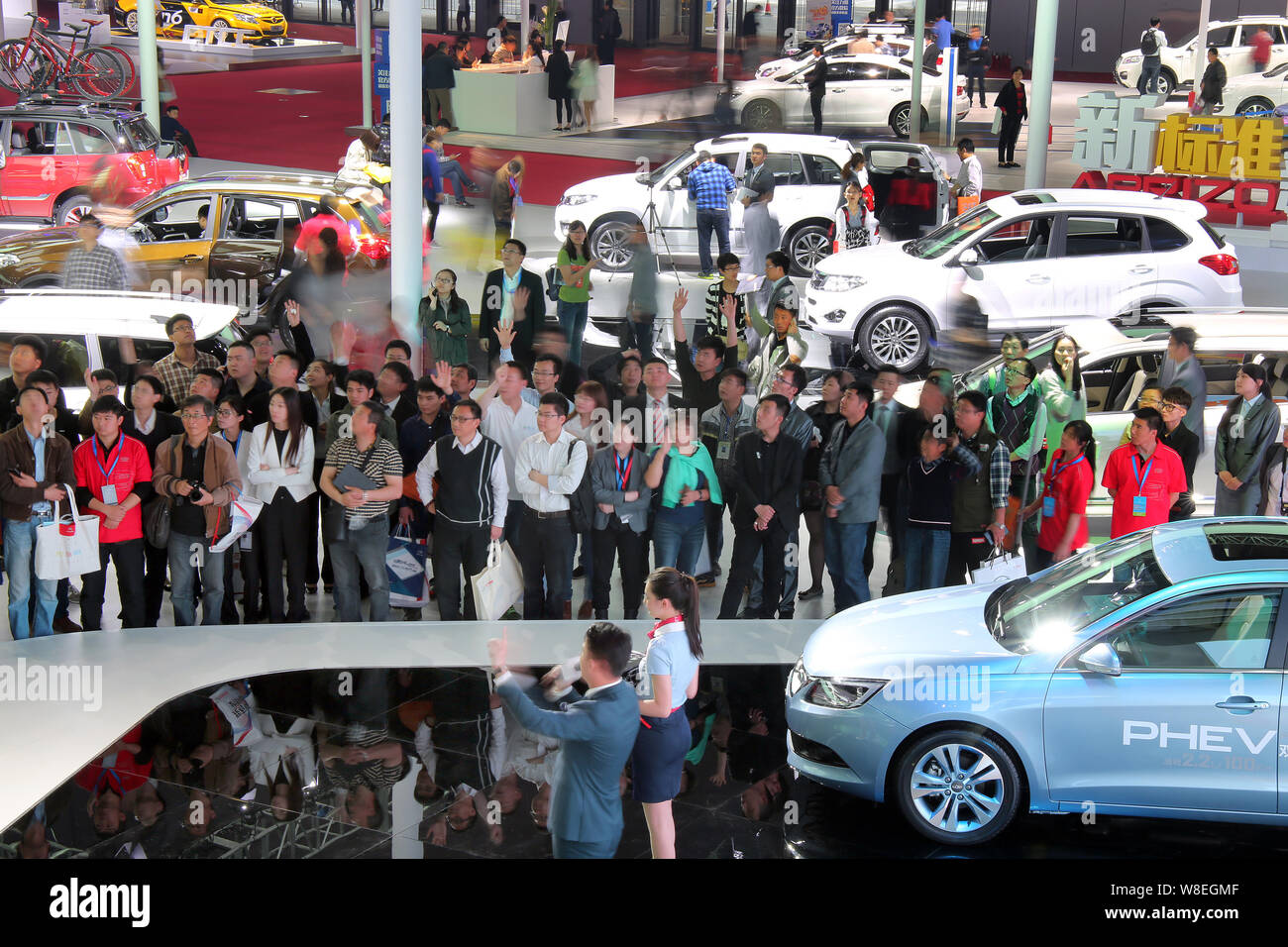 Visitors look at electric vehicles at the stand of Chery during the ...