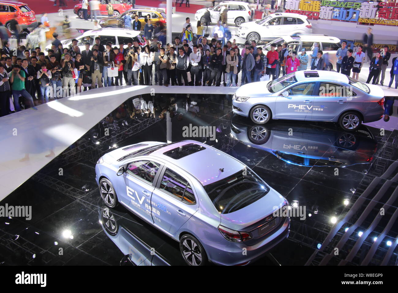 Visitors look at electric vehicles at the stand of Chery during the ...