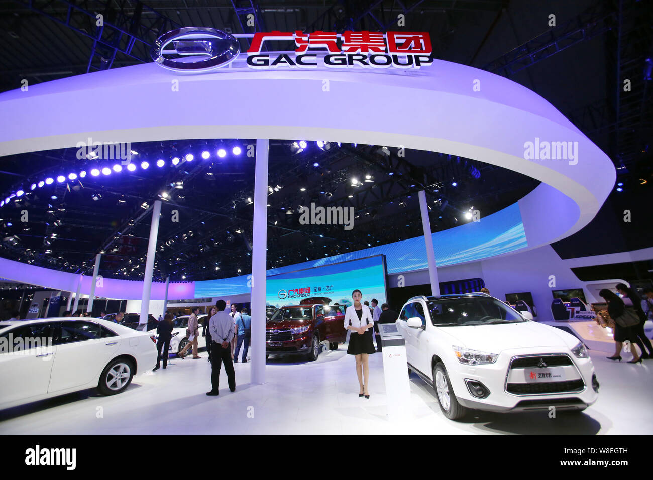 --FILE--Visitors look at cars on display at the stand of GAC Group ...