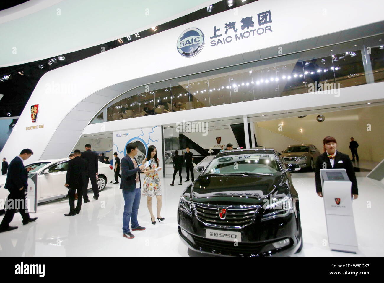 --FILE--Visitors look at Roewe 950 cars of SAIC Motor on display during ...