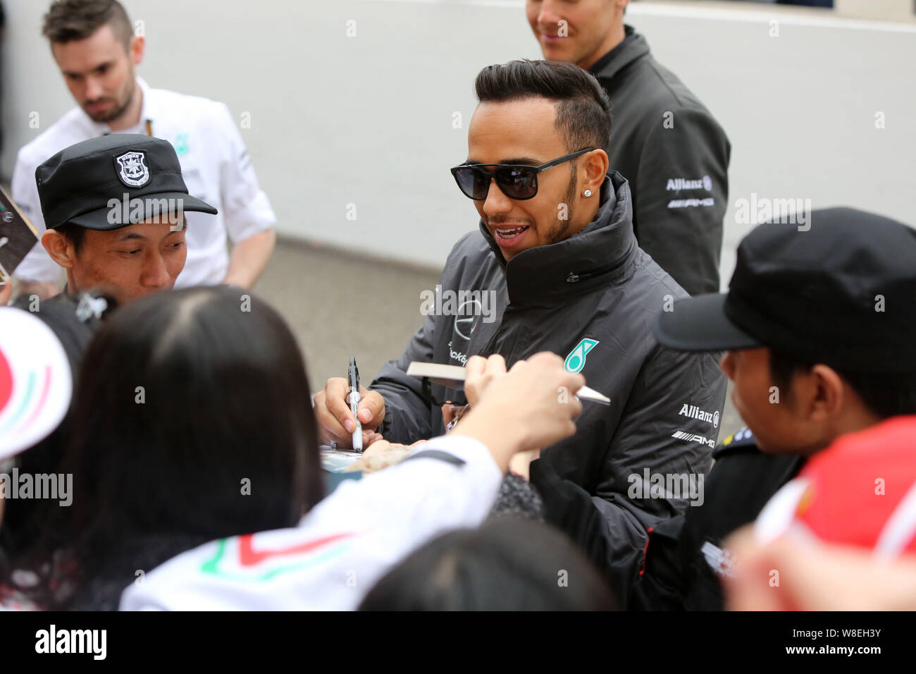 British F1 driver Lewis Hamilton of Mercedes signs autographs for fans ...