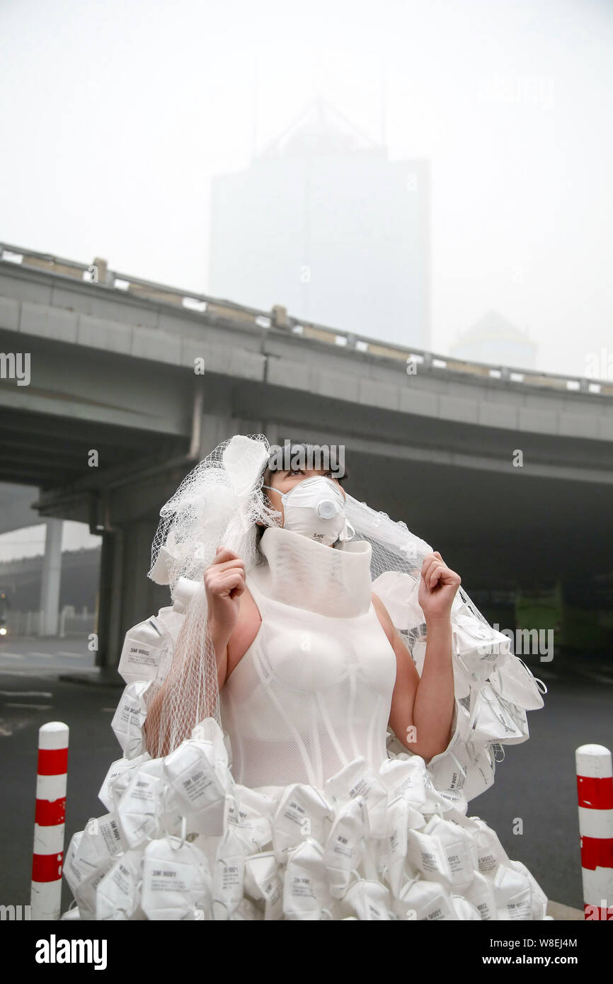 Chinese artist Kong Ning wearing a face mask and a wedding dress made ...