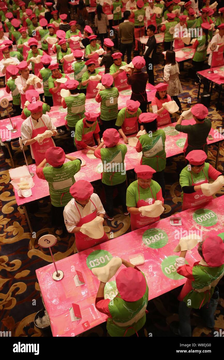 Participants toss pizza dough during an event to set a new Guinness ...