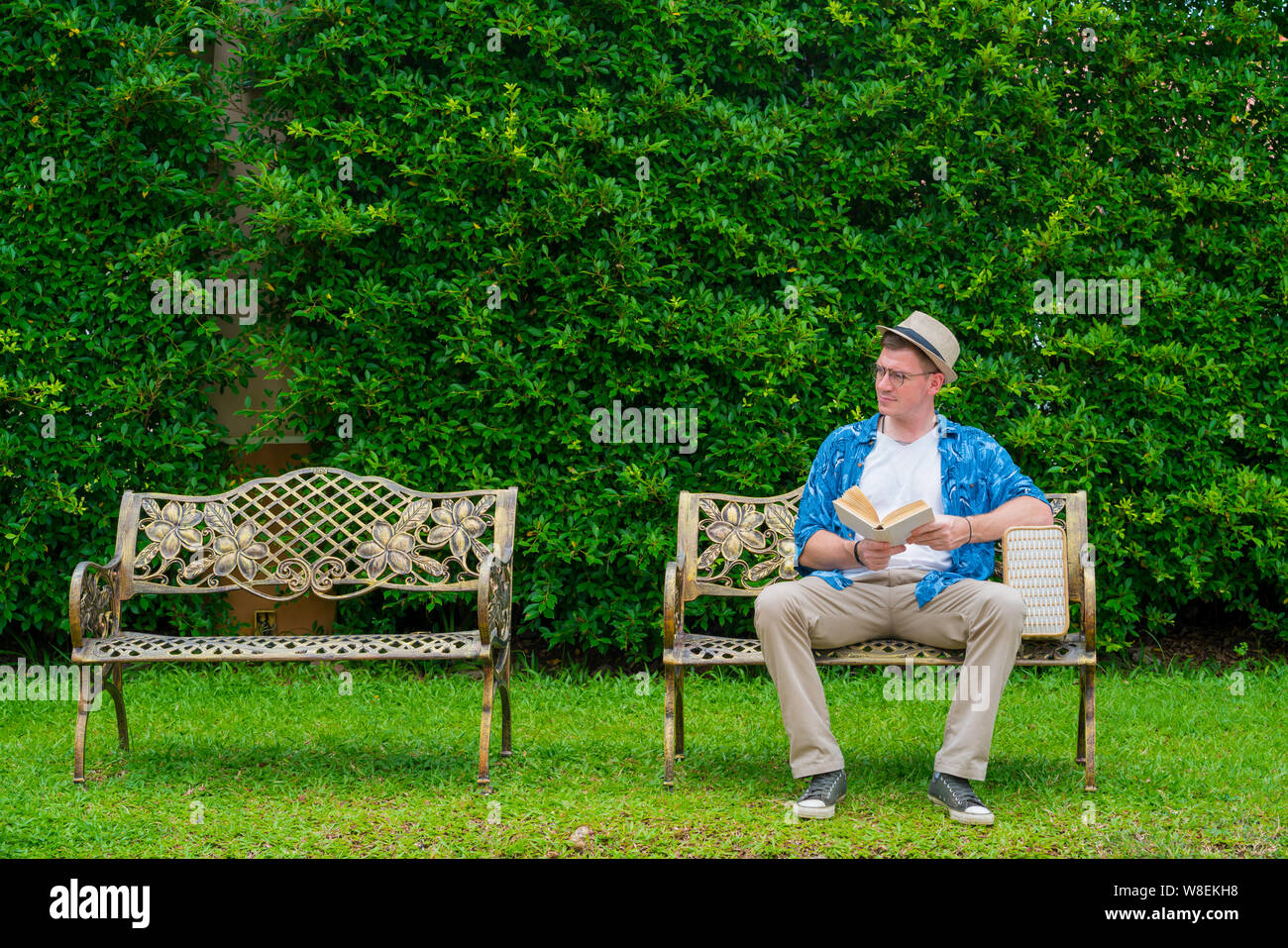 Old man looking at book garden hi-res stock photography and images - Alamy