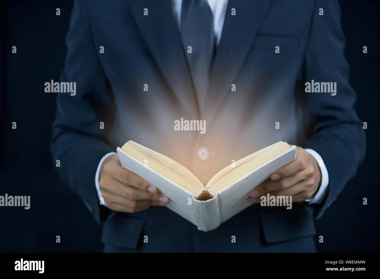 man wearing a suit reading a book on black background Stock Photo - Alamy
