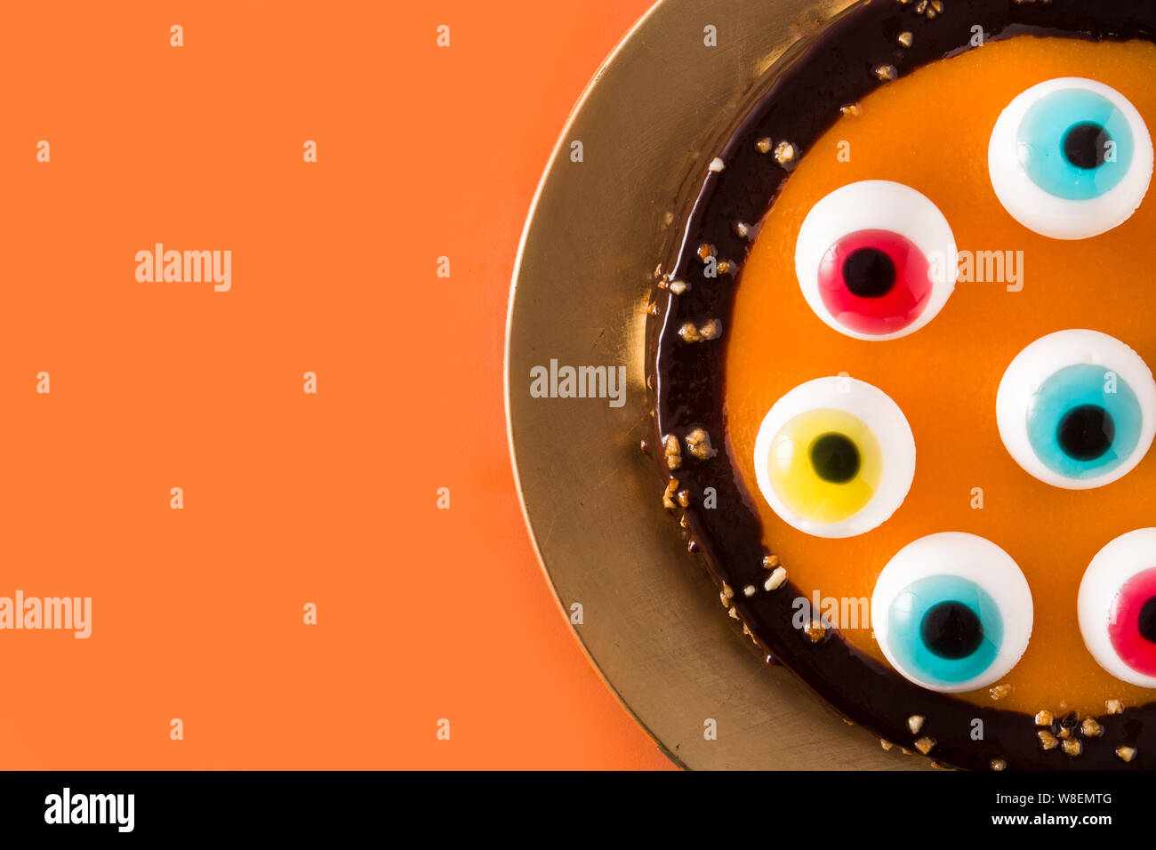 Halloween cake with candy eyes decoration on orange background. Top ...