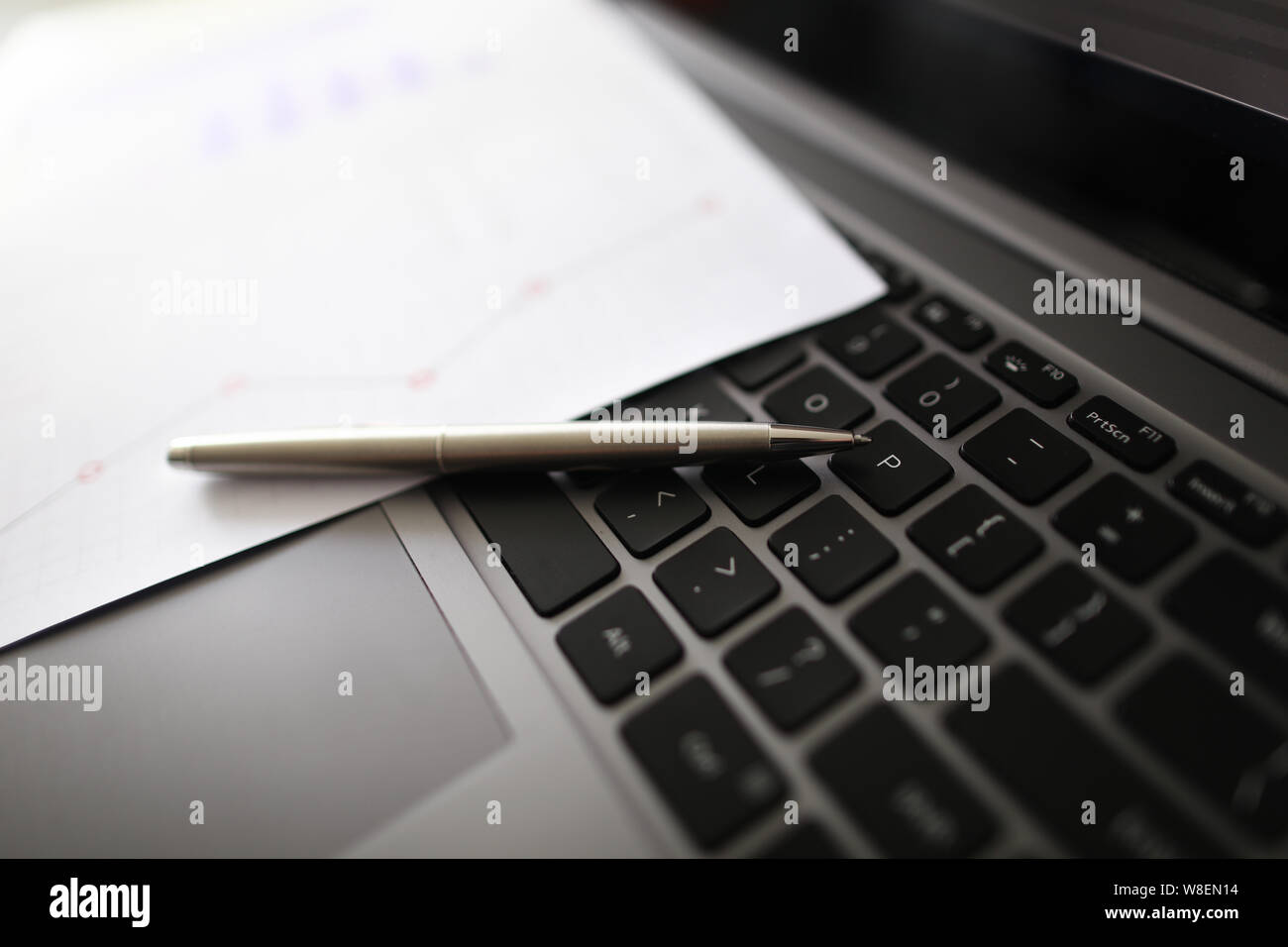Laptop black keyboard with pen paper Stock Photo - Alamy