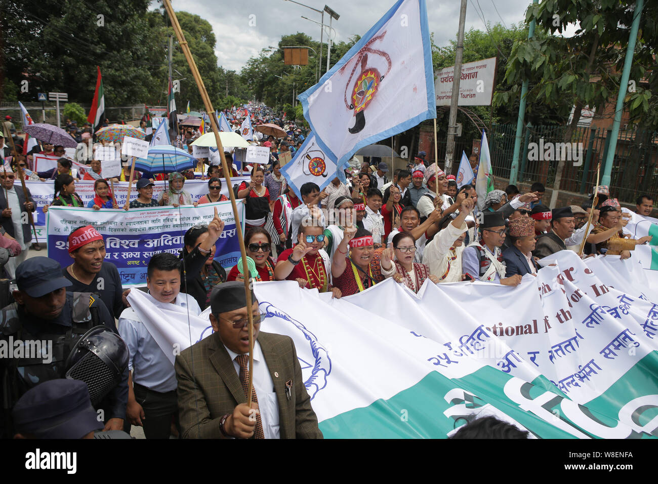 Nepalese indigenous people hold banners and flags during the march ...